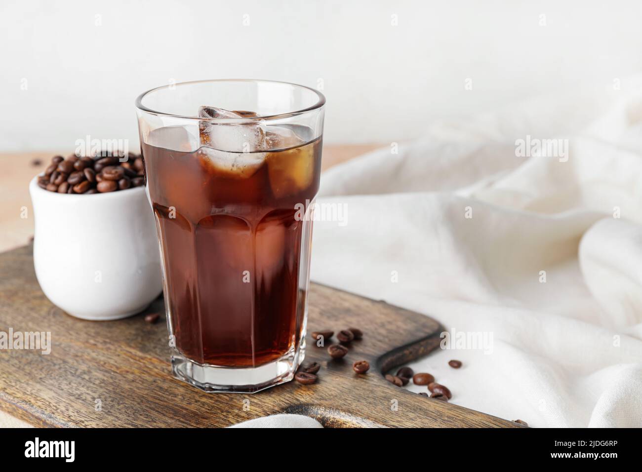 Wooden board with glass of cold brew and coffee beans on table Stock ...