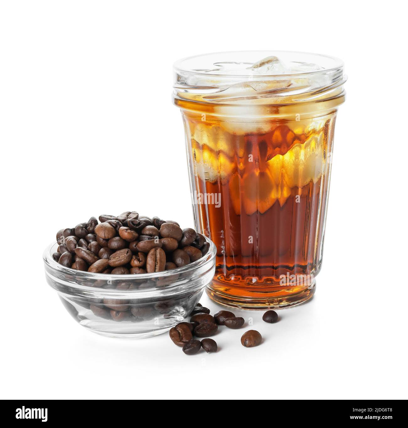Glass with cold brew and bowl with coffee beans on white background ...