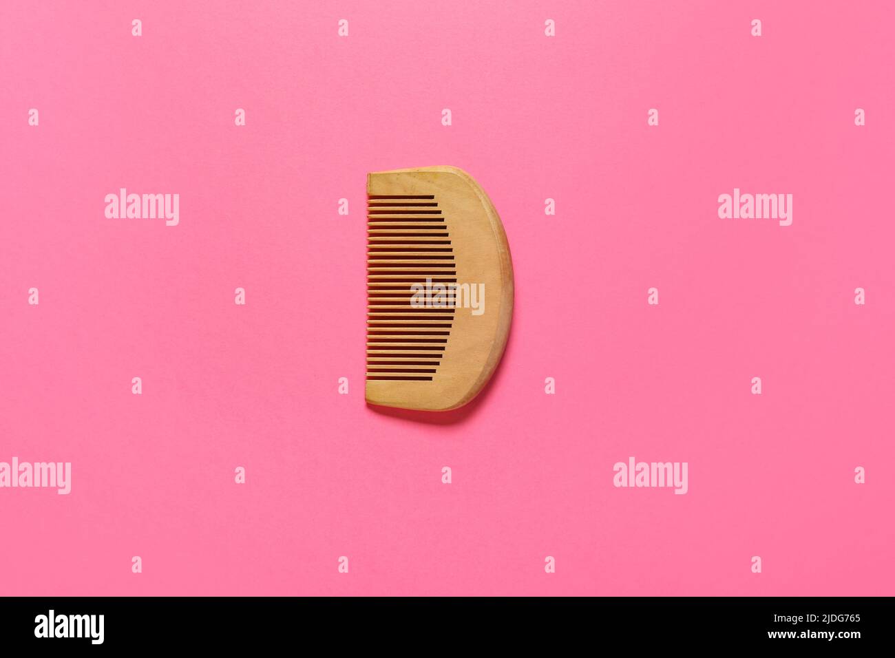 Wooden hair comb for baby on pink background Stock Photo - Alamy