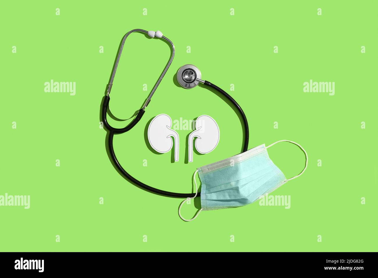 Paper kidneys with stethoscope and medical mask on green background ...