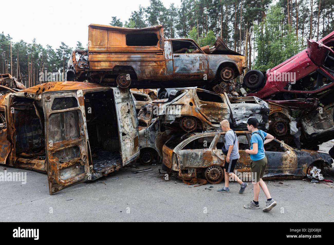 Irpin, Ukraine. 17th June, 2022. Two boys look at the cars that were ...