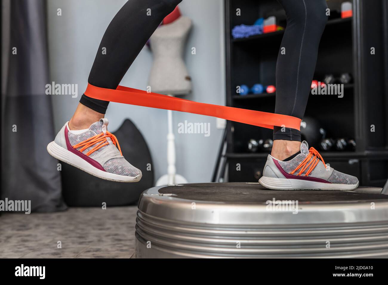 Feet of unknown woman and rubber elastic resistance band while standing ...
