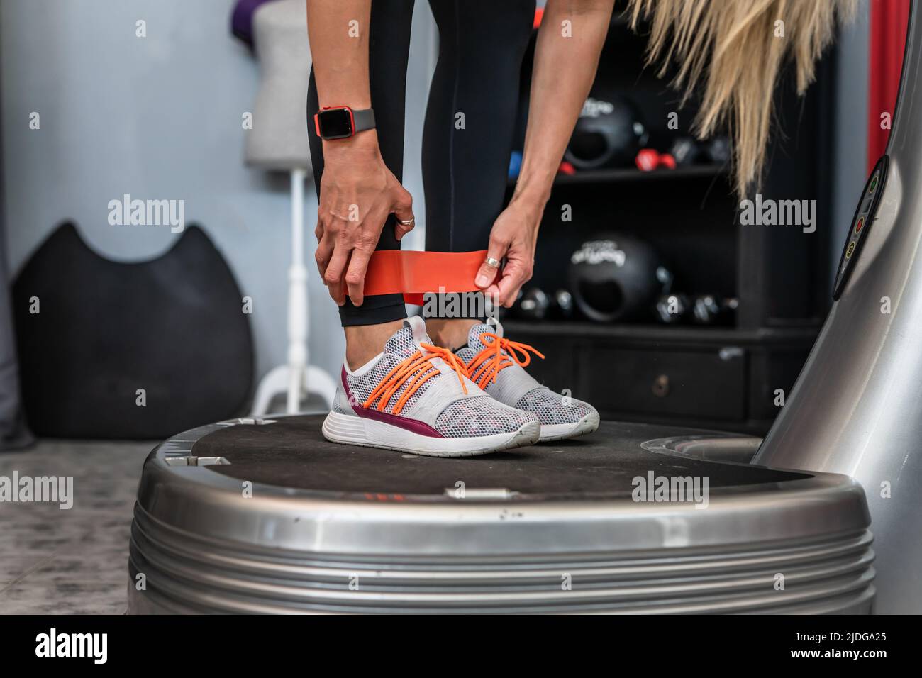 Feet of unknown woman adjust rubber elastic resistance band while ...