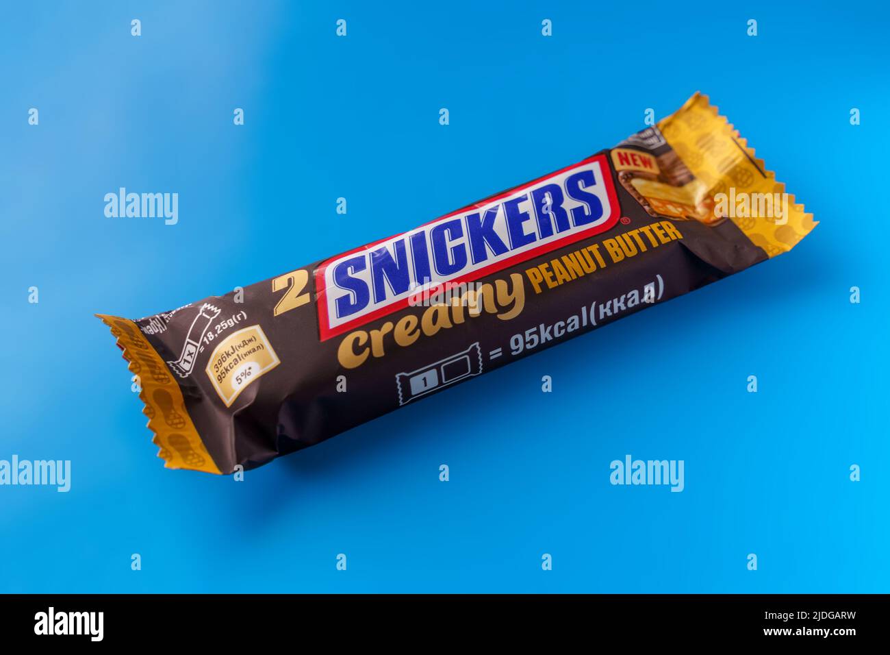 Chocolate bar Snickers on a blue background, soft focus Stock Photo - Alamy