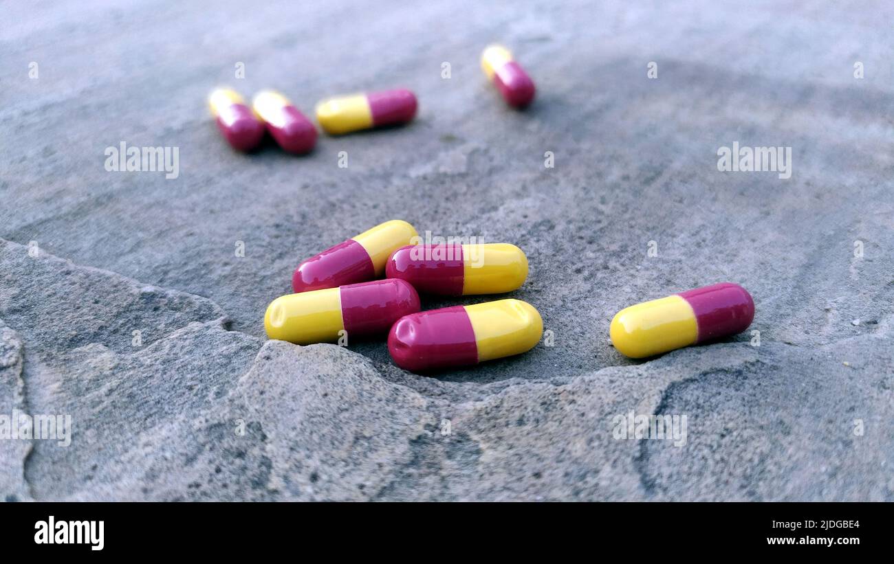 some medicine capsule isolated on stone background Stock Photo - Alamy