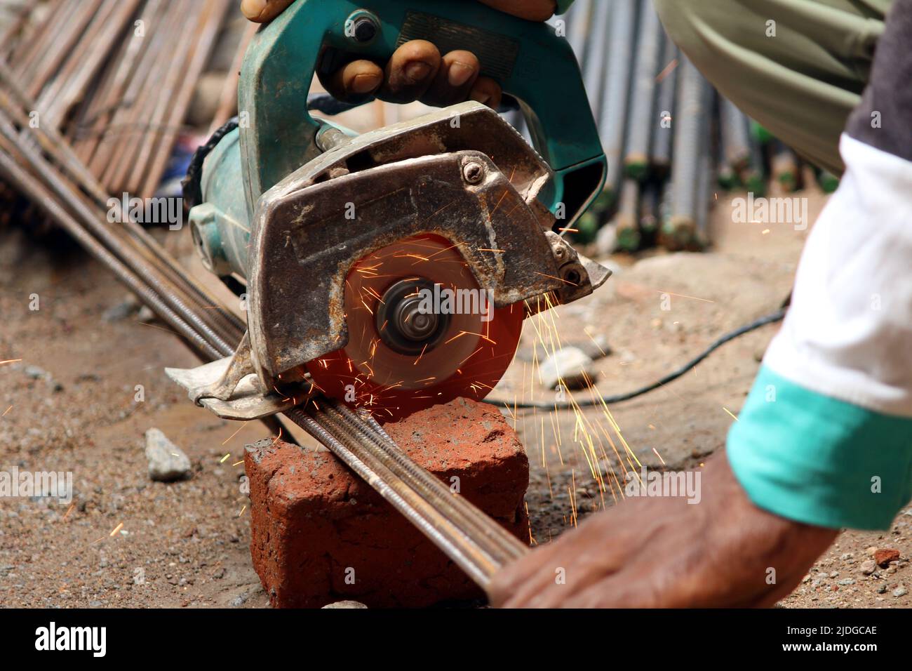 a worker cutting iron rods on construction site Stock Photo - Alamy