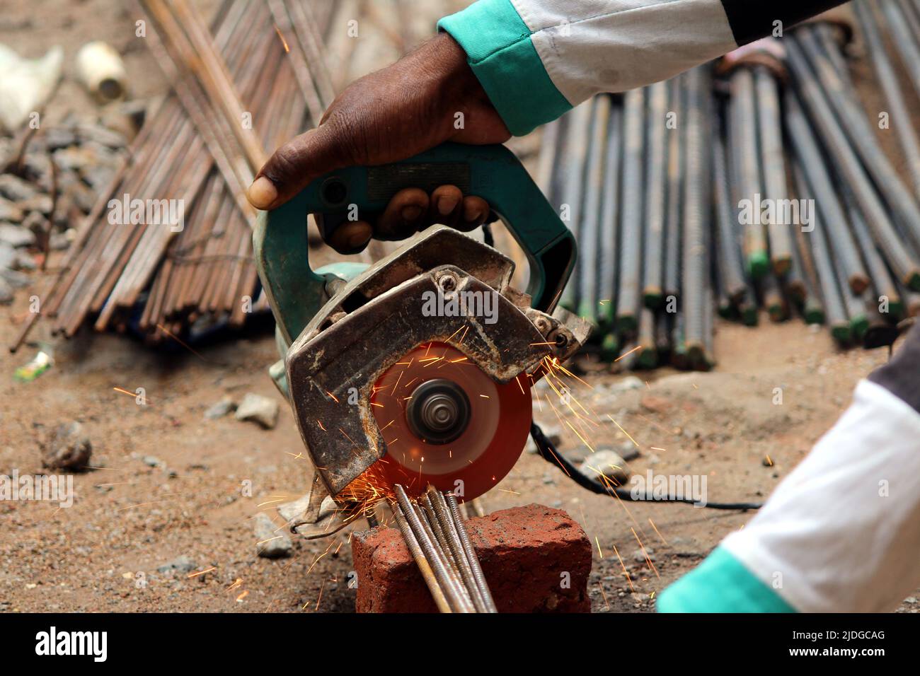 a worker cutting iron rods on construction site Stock Photo - Alamy