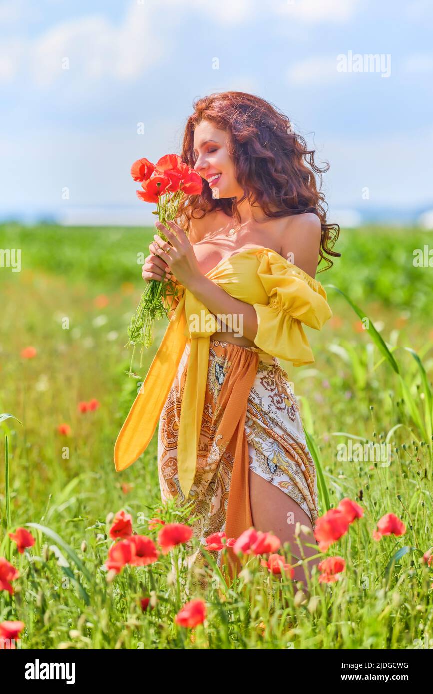 Attractive woman in a poppy field with flowers in full bloom Stock ...