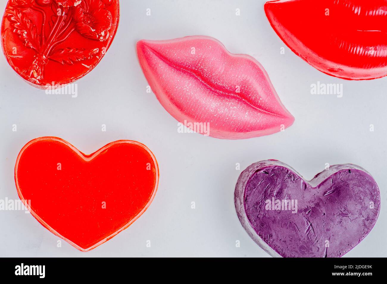 Close up flat lay of pieces of soap shaped and coloured like hearts and ...