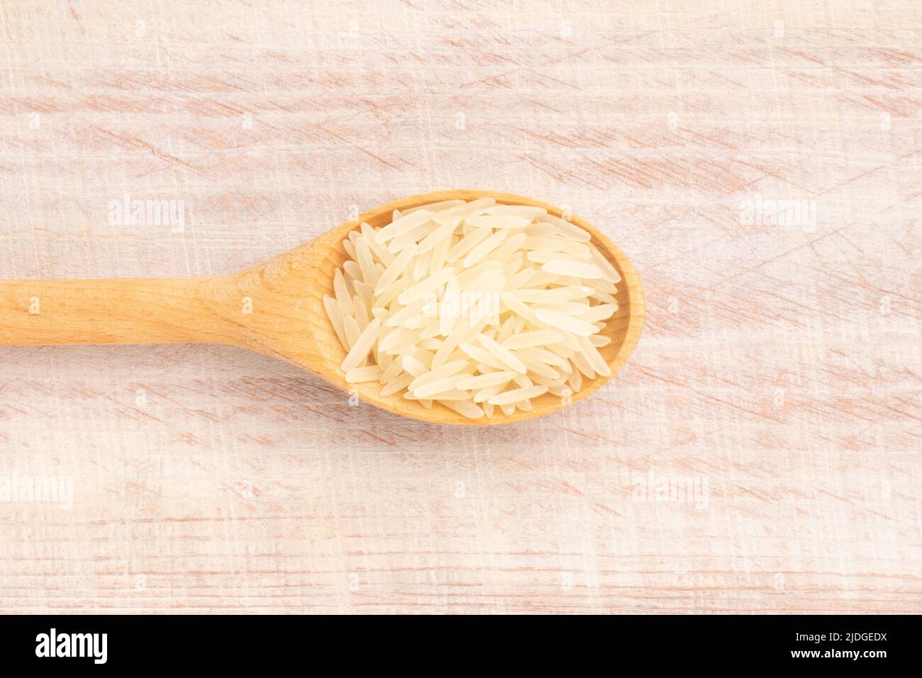 Long Basmati rice in wooden spoon on brown wooden background. Flat lay ...