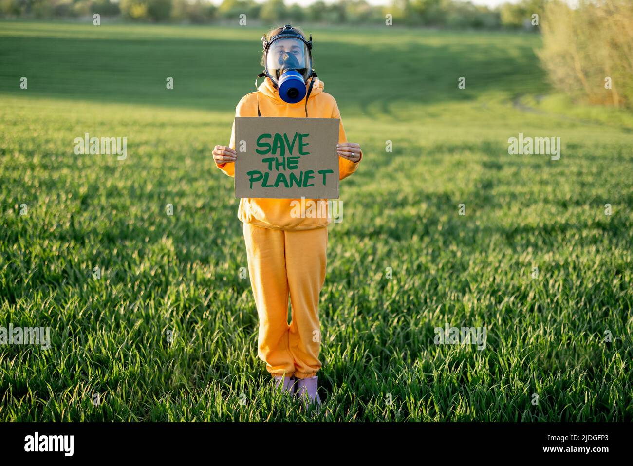 Person in gas mask holds cardboard with a call to save the planet Stock ...