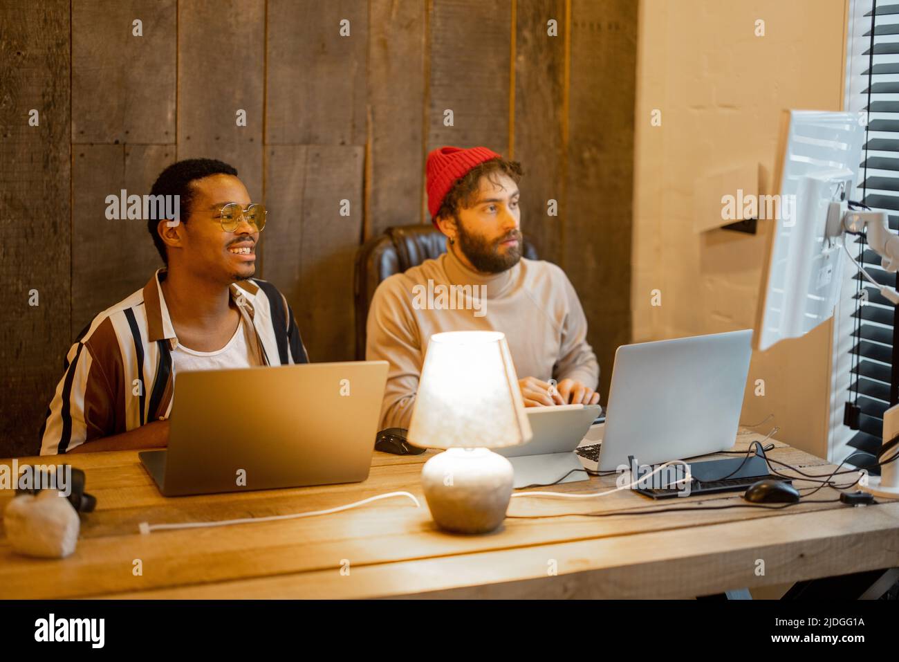 Two men working on computer at home office Stock Photo - Alamy