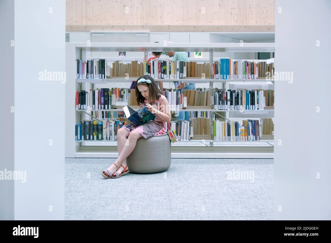 Girl sitting on a Pouf reading at Gabriel Garcia Marquez Public Library ...