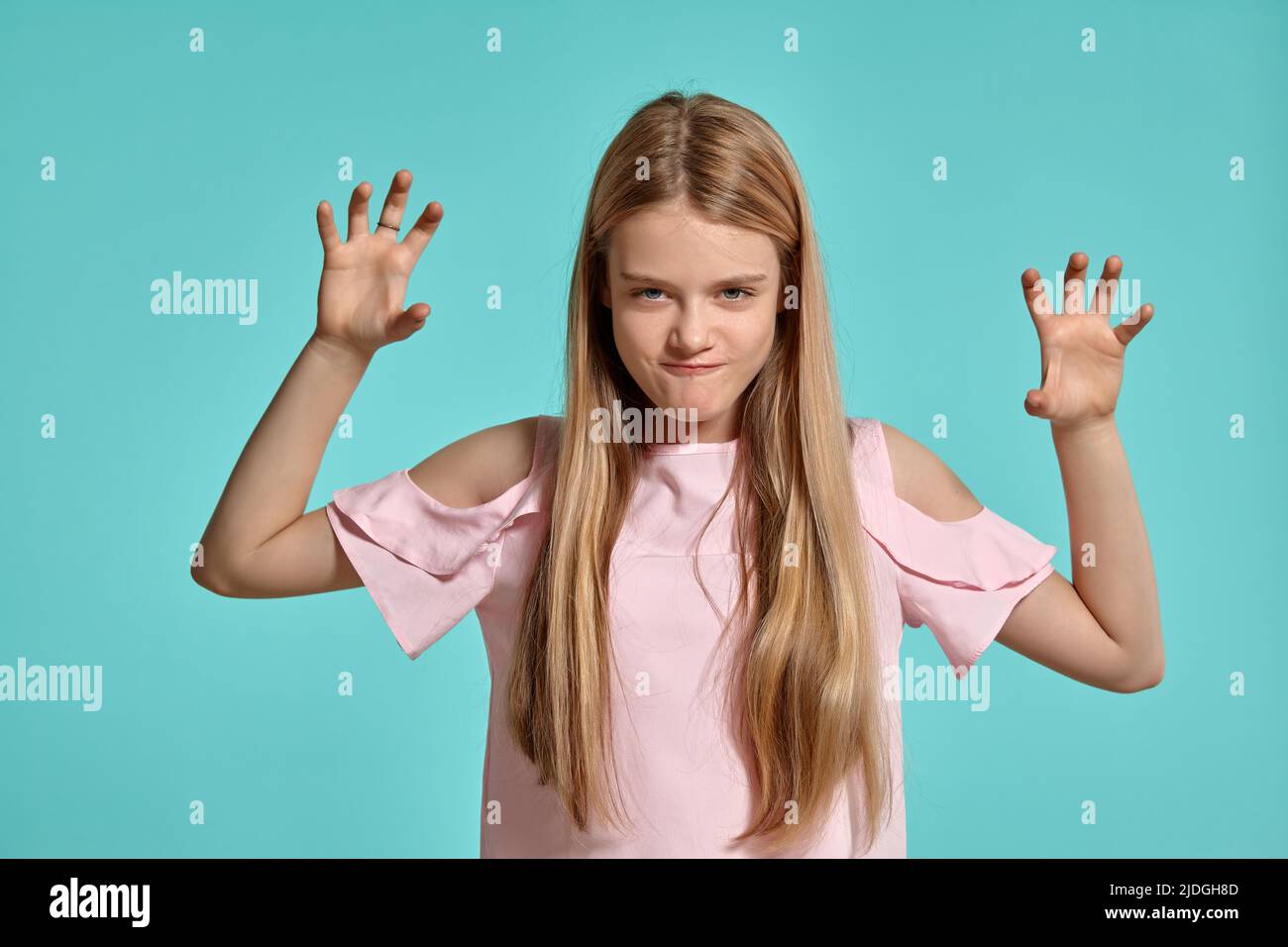 Studio portrait of a beautiful girl blonde teenager in a pink t-shirt ...