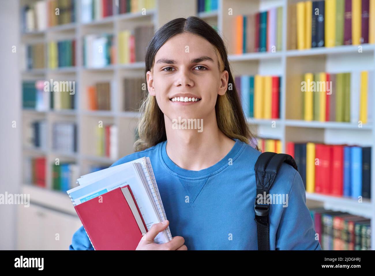 Portrait of a student guy with textbooks looking at camera in college ...