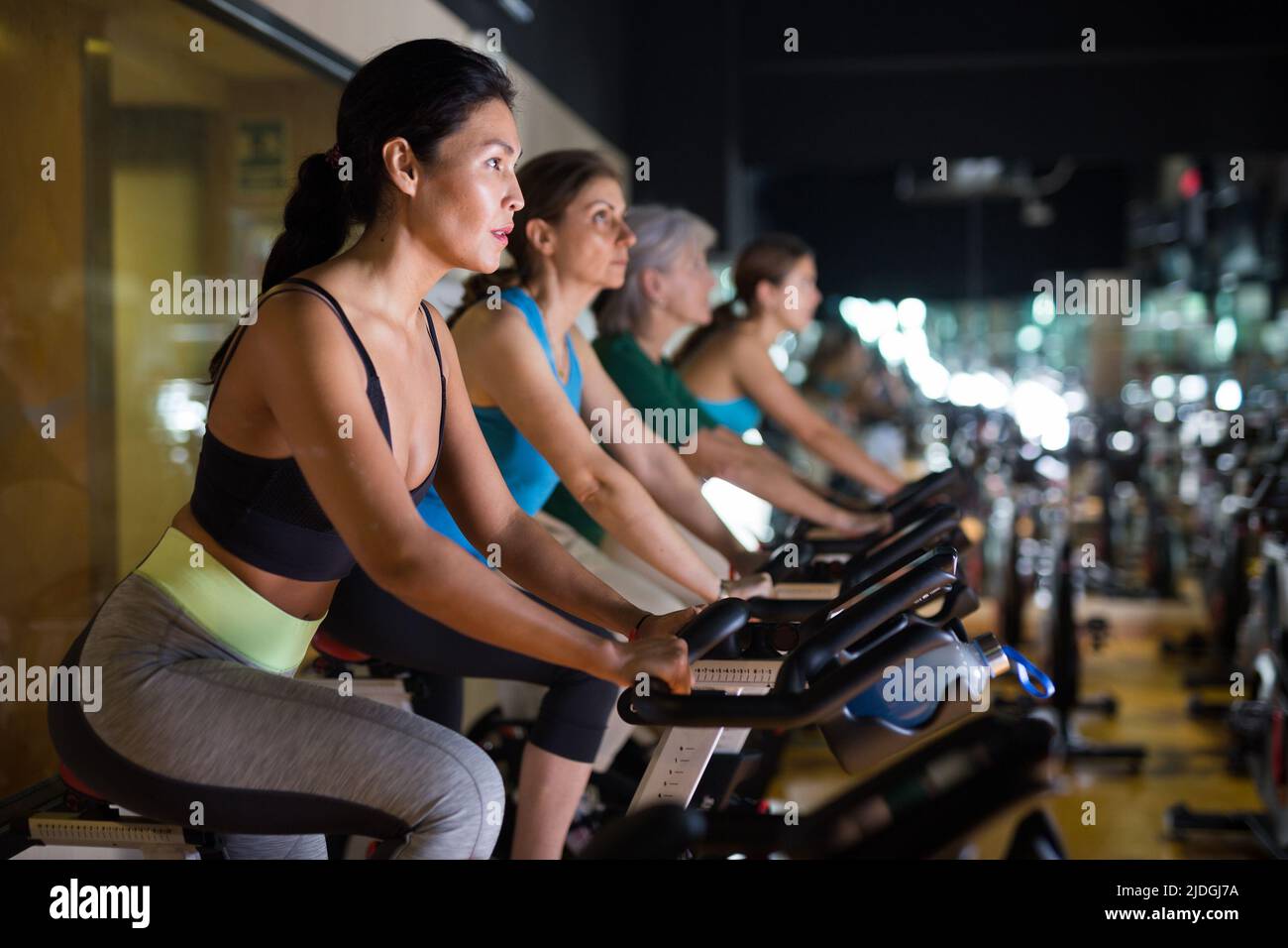 Woman on stationary bike workout in gym Stock Photo - Alamy