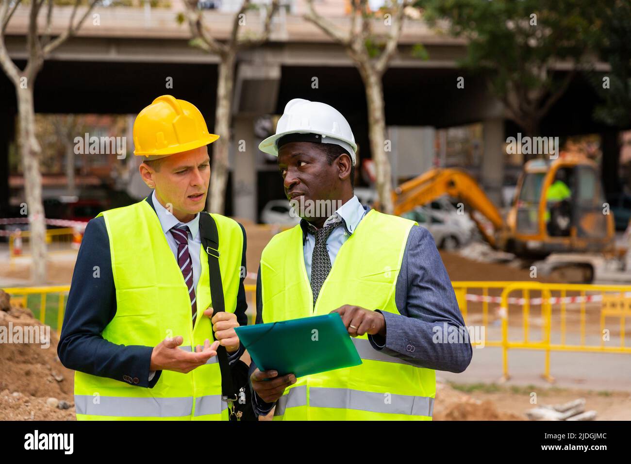 Two engineers talking about road repairing works documentation Stock ...