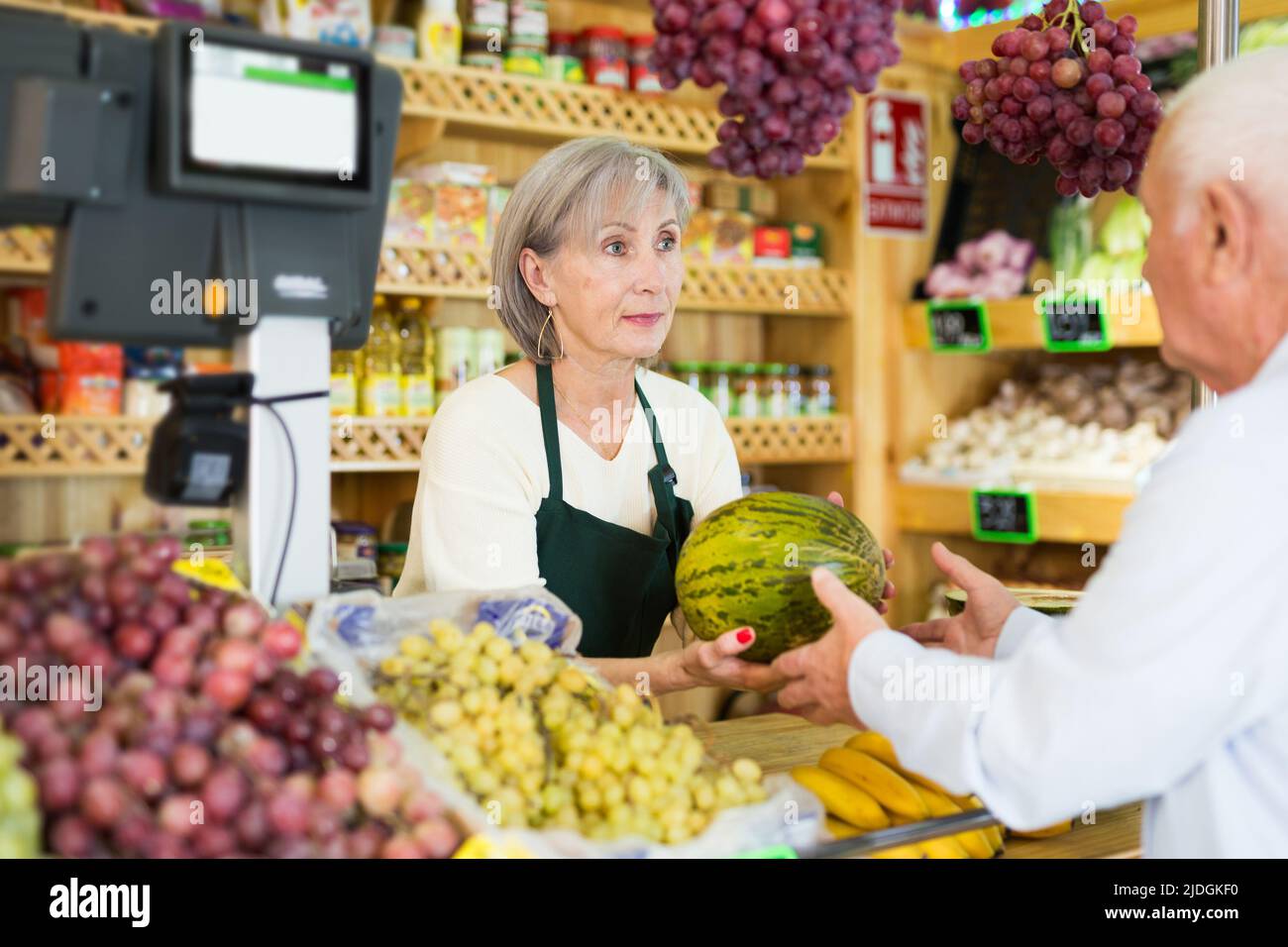 Senior cashier woman serving customer in greengrocer Stock Photo - Alamy