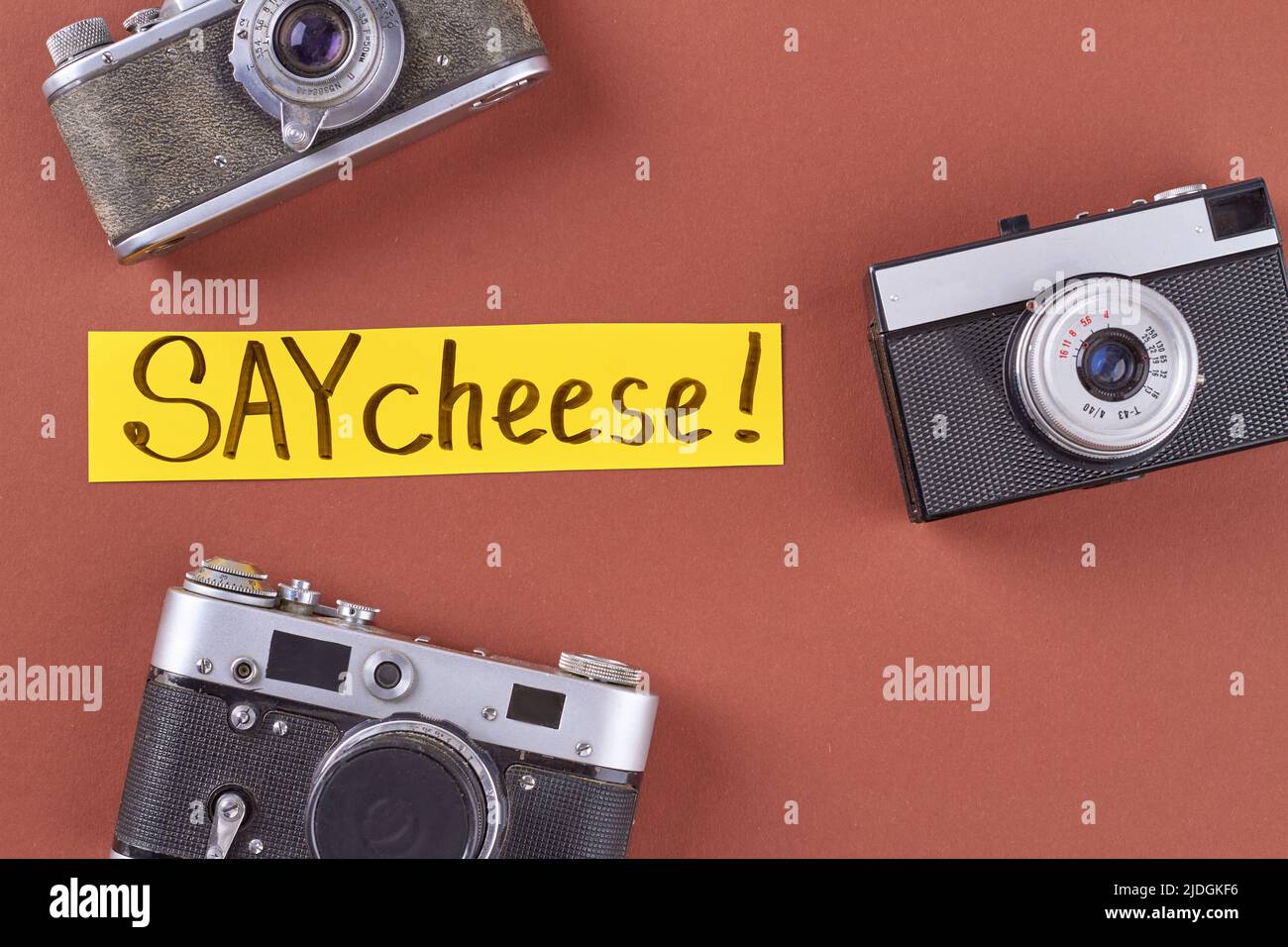 Top view three retro photo cameras on red background. Say cheese ...