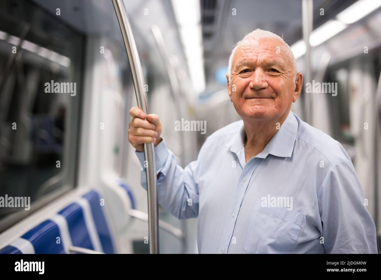 Senior man standing inside subway train Stock Photo - Alamy