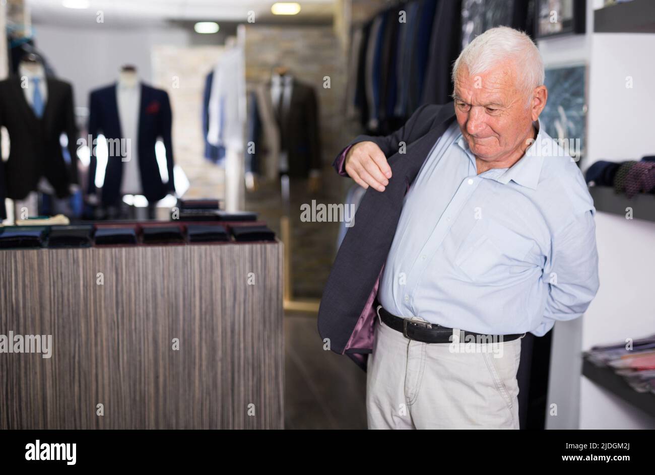 Mature male shopper shows off his jacket at men's store Stock Photo - Alamy