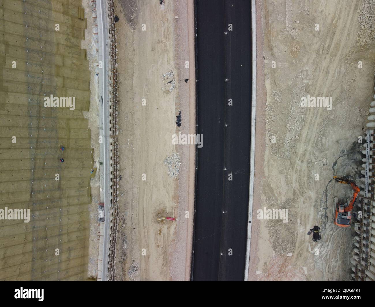 Workers reinforce the slope over the new road. Road construction in ...