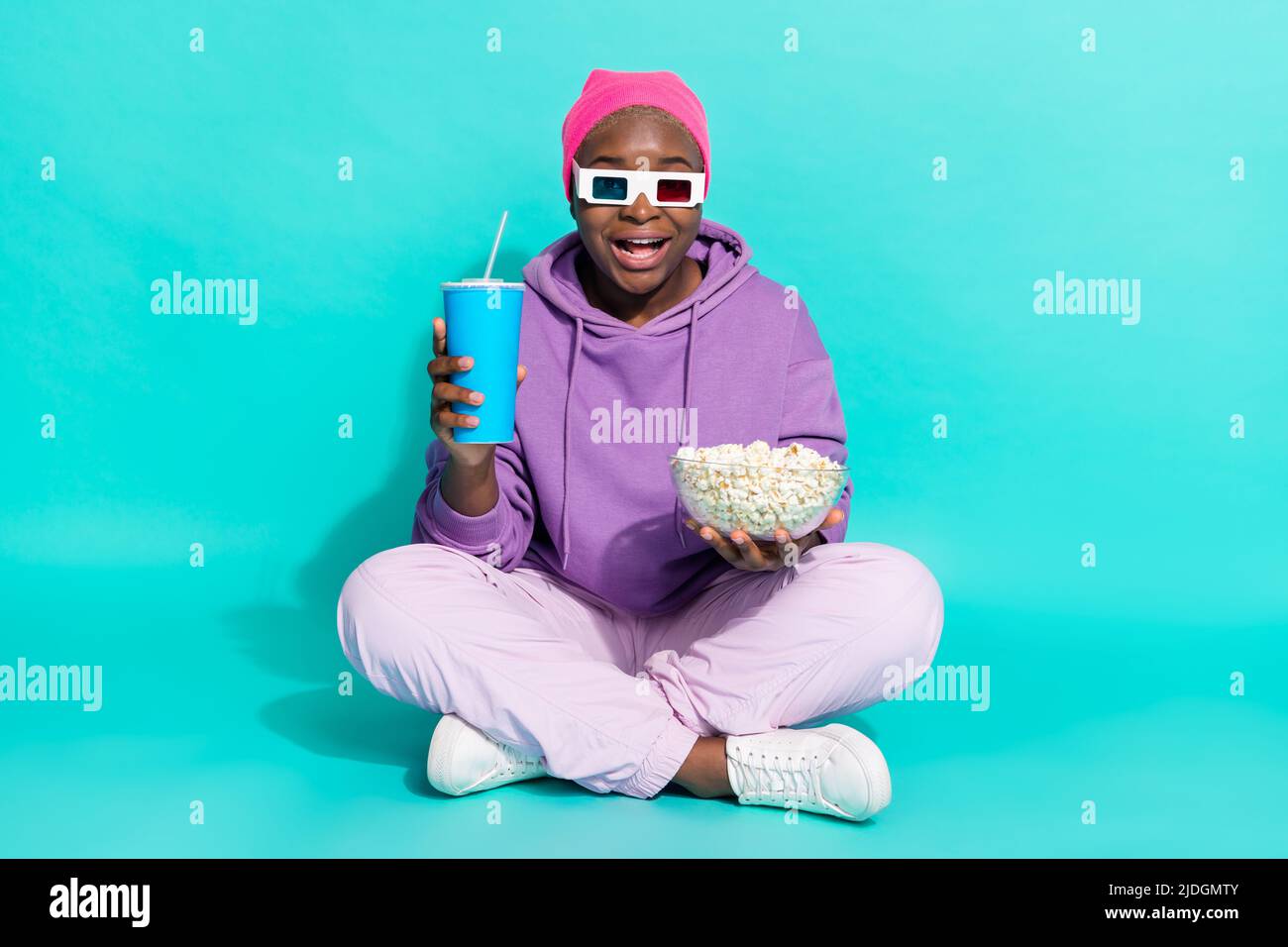 Portrait of attractive cheerful girl sitting watching tv series having ...