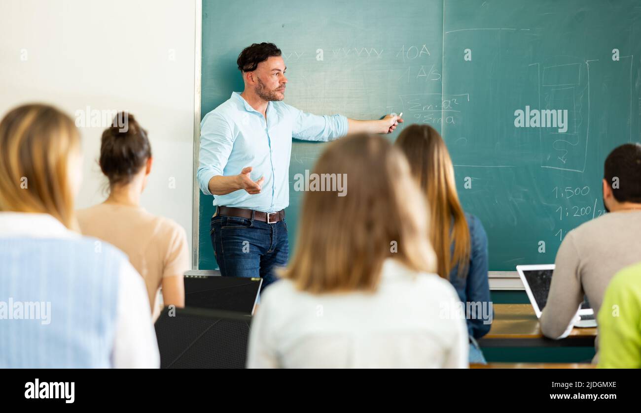 Young teacher is giving a lecture to students Stock Photo - Alamy