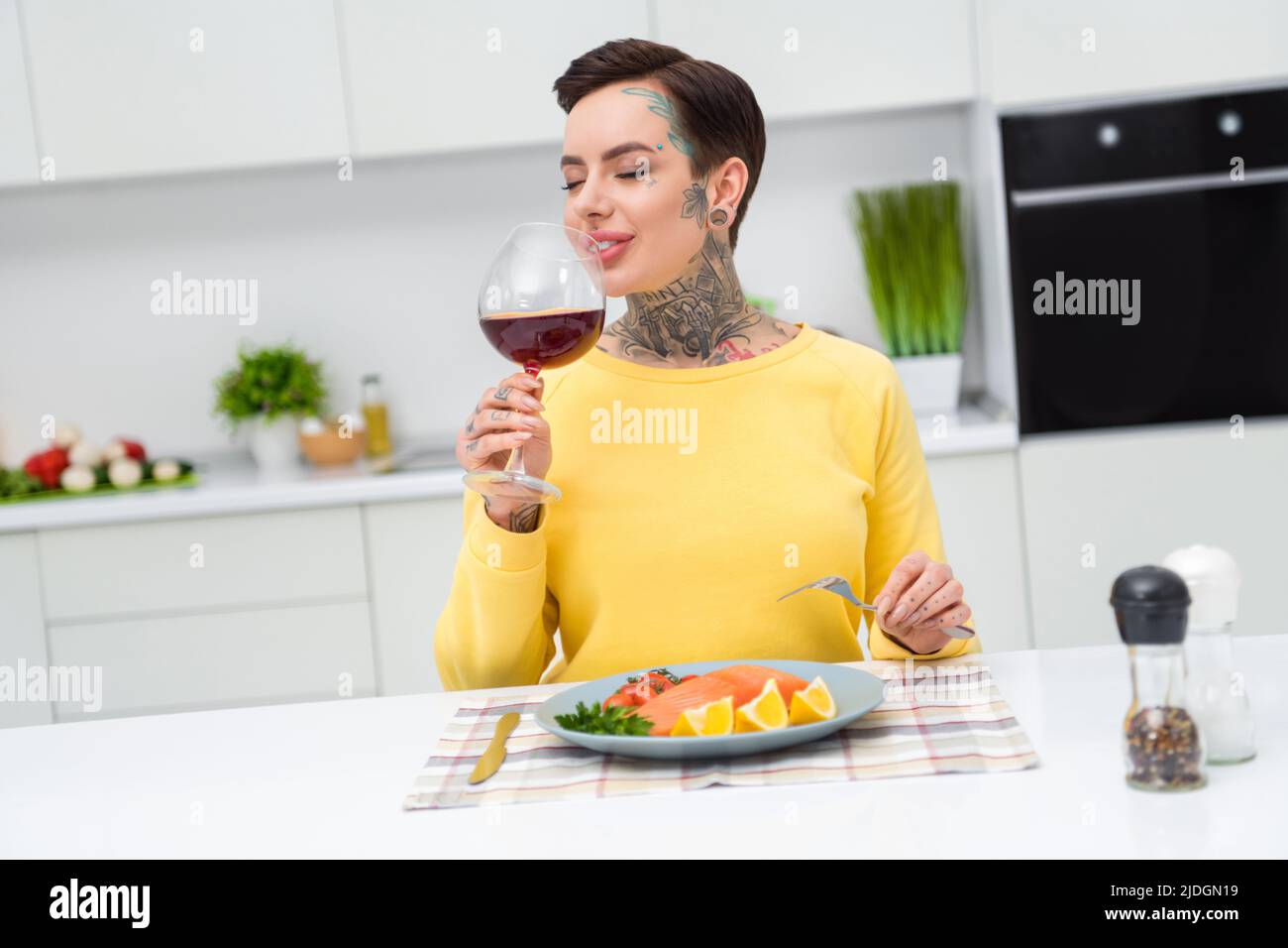 Portrait of attractive dreamy cheerful girl eating fresh dish drinking ...