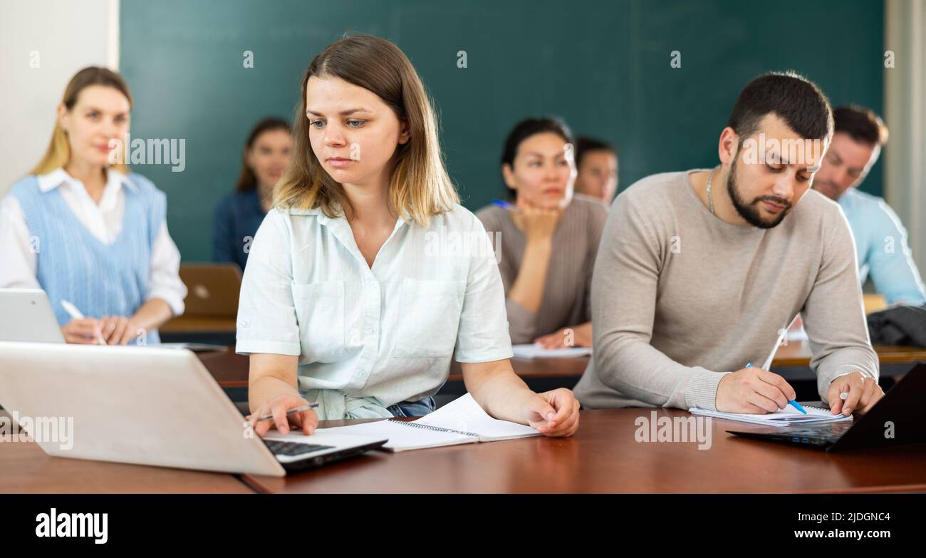 Focused students write down the lecture synopsis during the class Stock ...