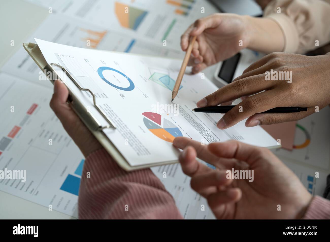 Close up diverse employees working on financial project statistics or ...