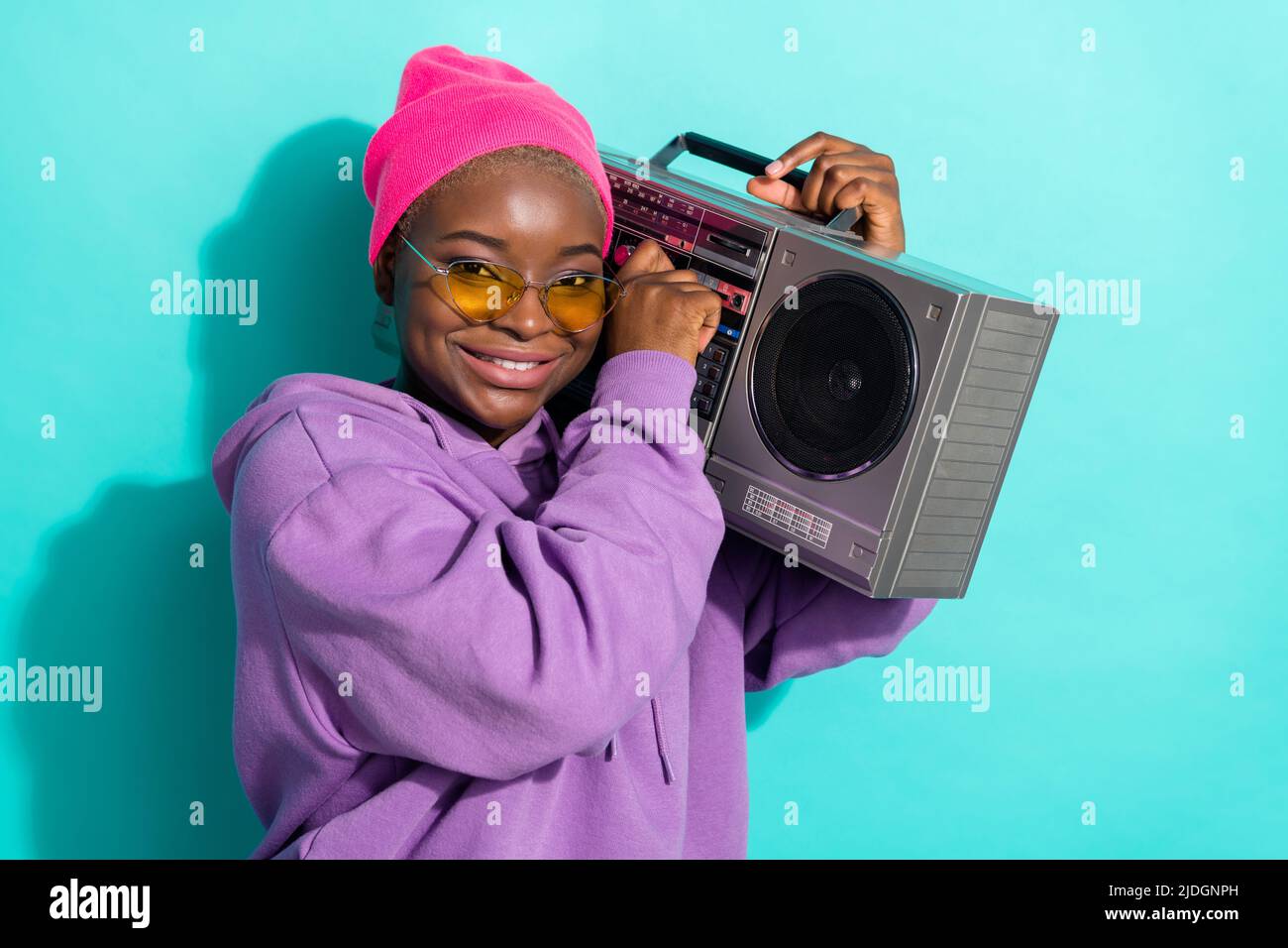 Portrait of attractive cheery girl carrying boombox listening hip hip ...