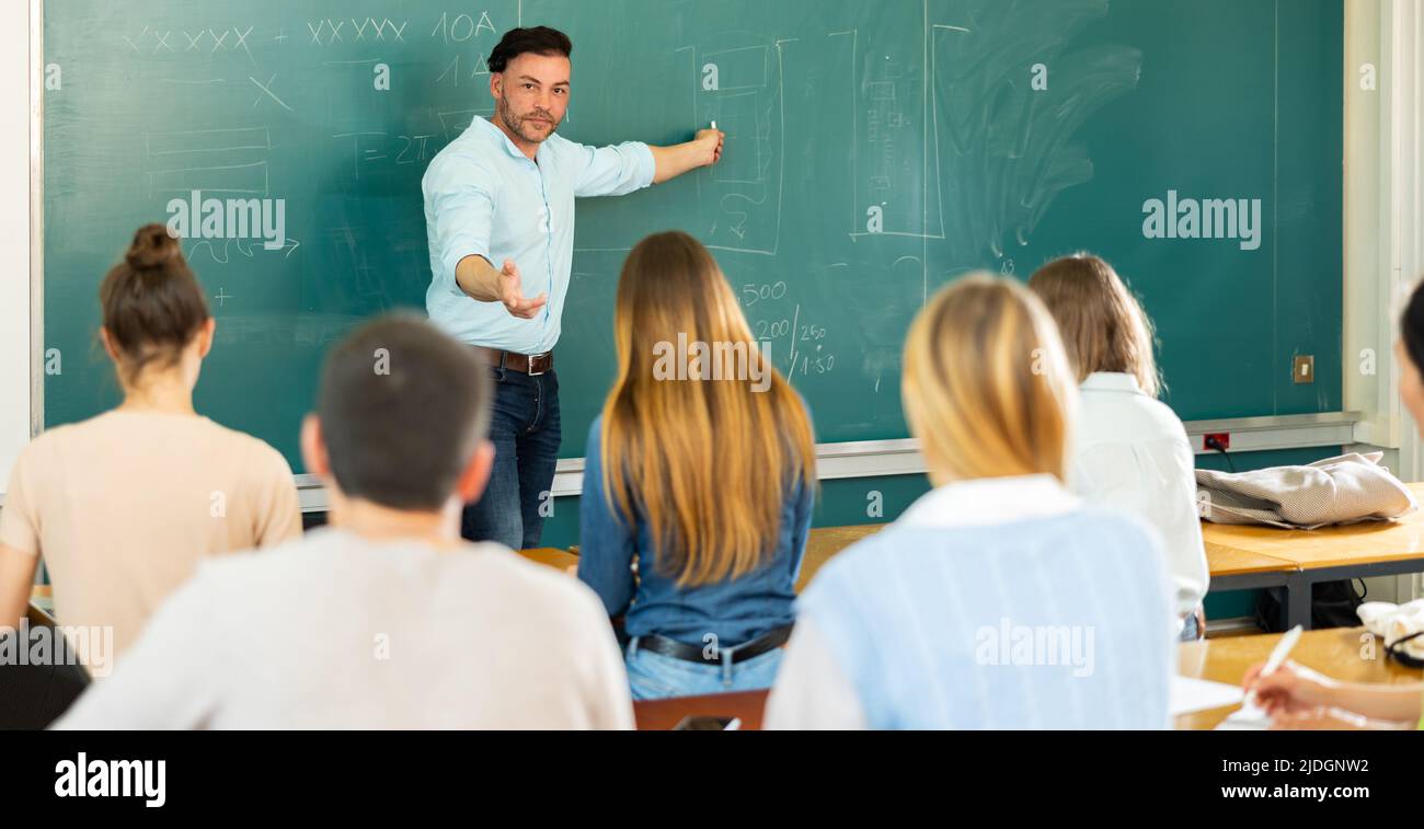 Male teacher giving presentation for students in lecture hall Stock ...