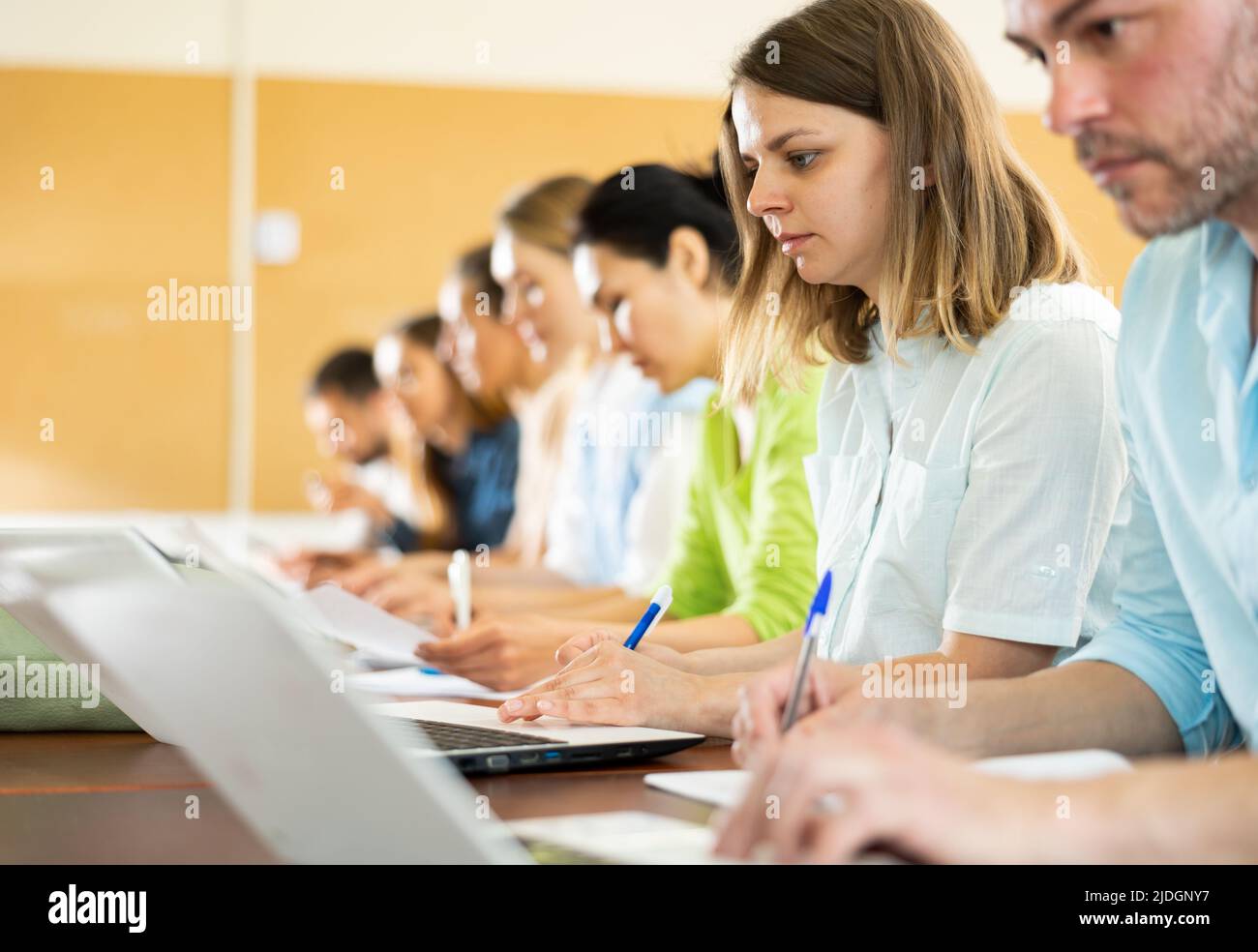 Woman university student writing in classroom Stock Photo - Alamy