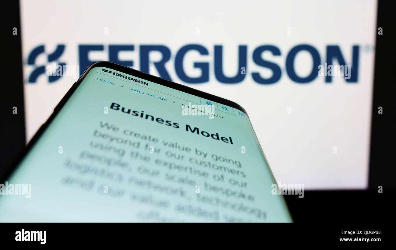 Mobile phone with webpage of British company Ferguson plc on screen in ...