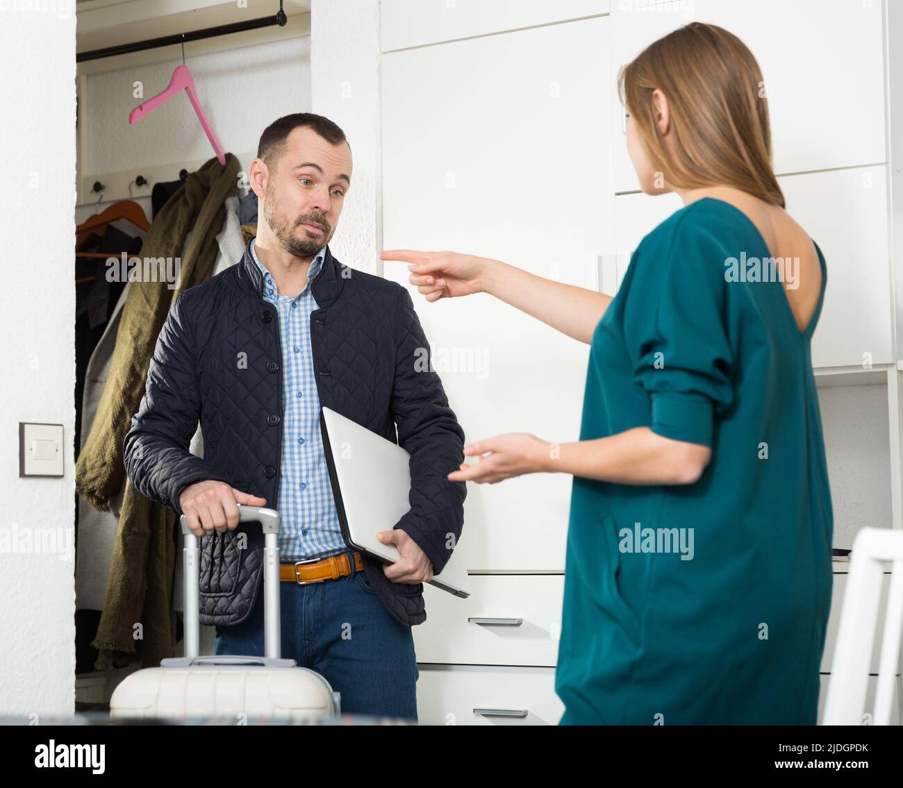 Woman pointing at door to boyfriend Stock Photo - Alamy
