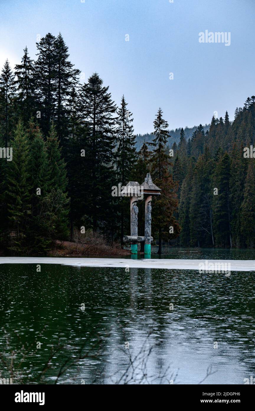 Alpine lake Synevyr, wooden statues near the lake, a tourist place in ...