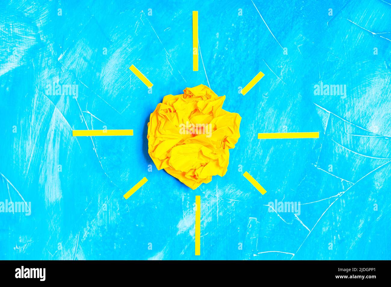 Sun symbol made from a crumpled paper ball on blue background Stock ...