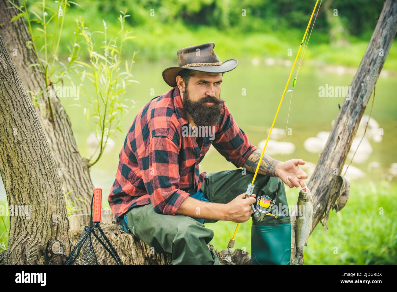 Fisherman caught a fish. Man fishing on river Stock Photo - Alamy