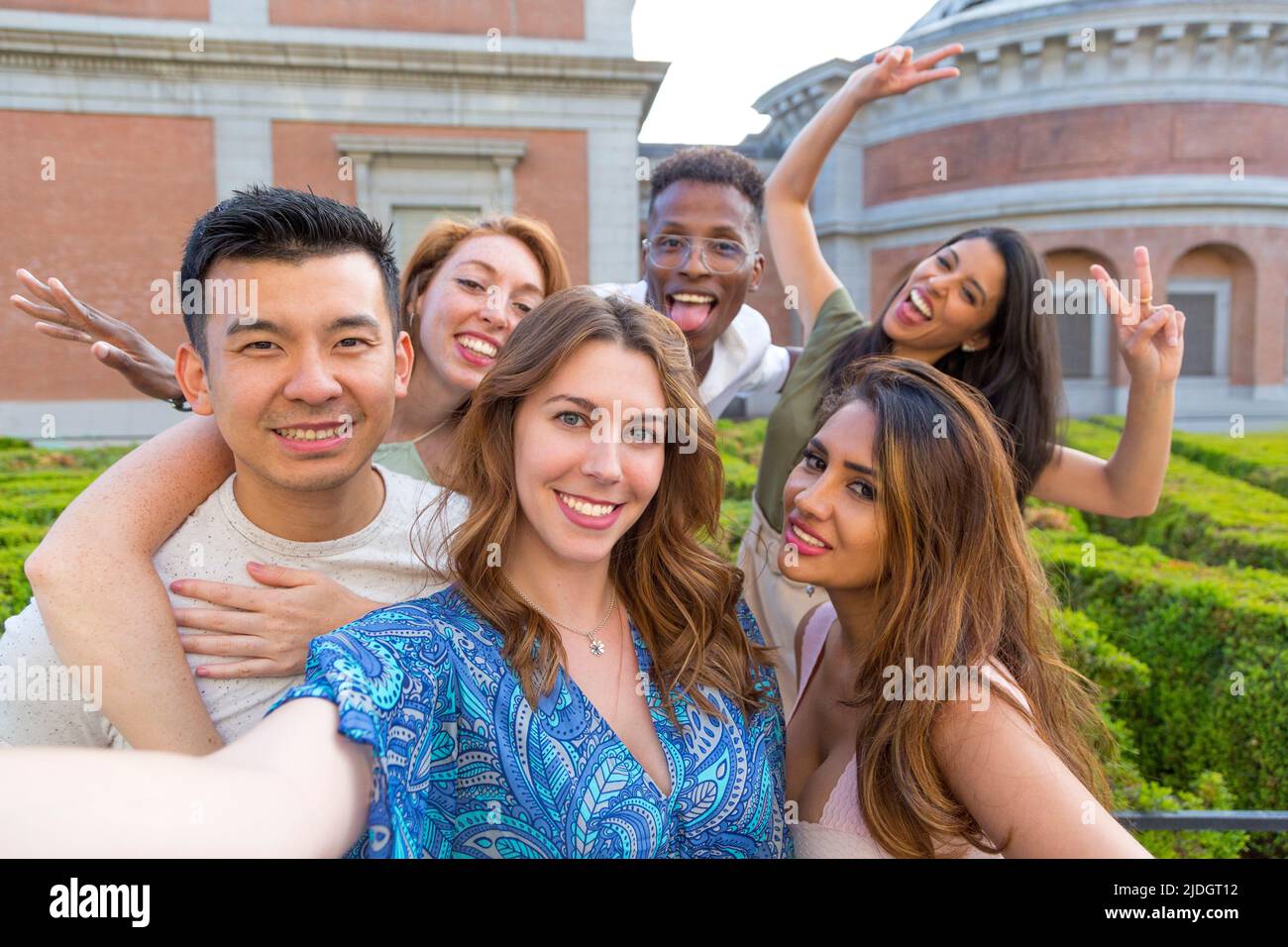 Multicultural group of friends posing and grimacing while taking a ...