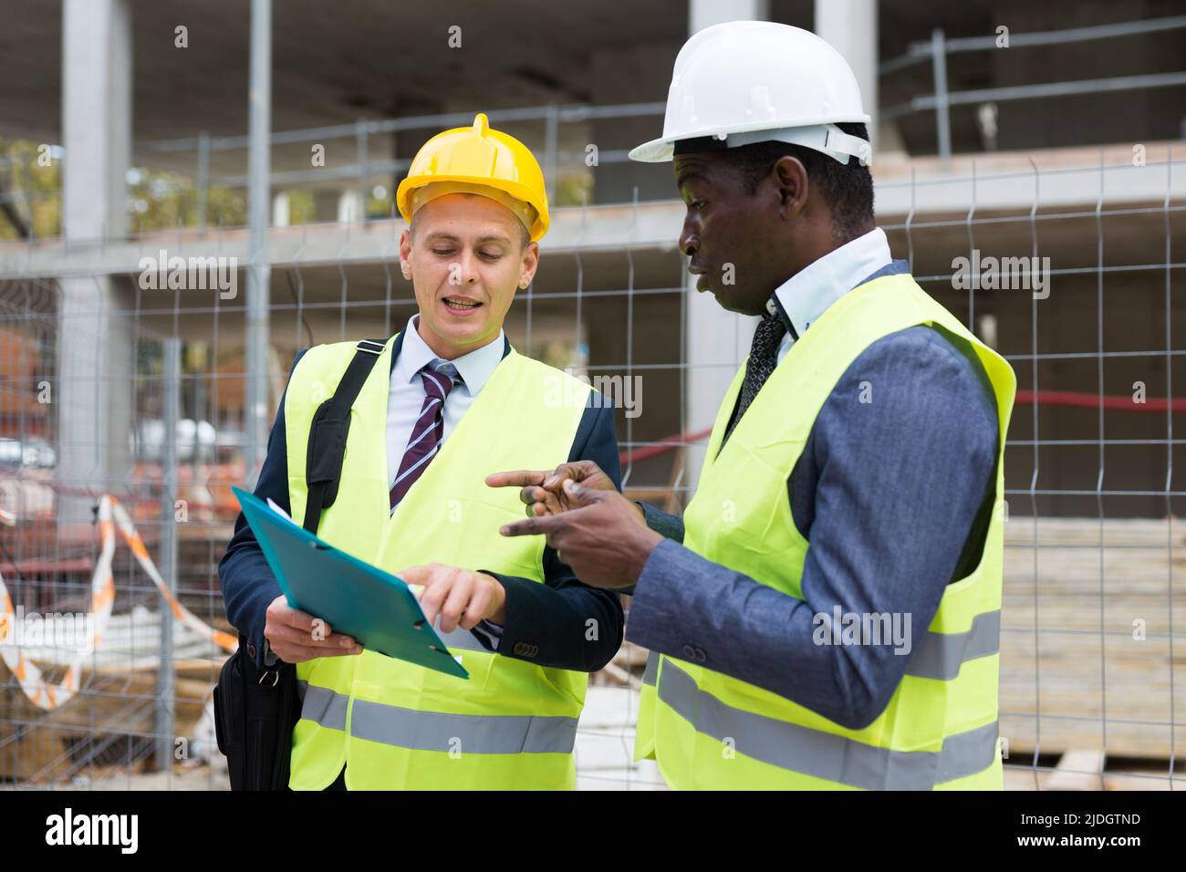 Builders talking about work outdoors Stock Photo - Alamy