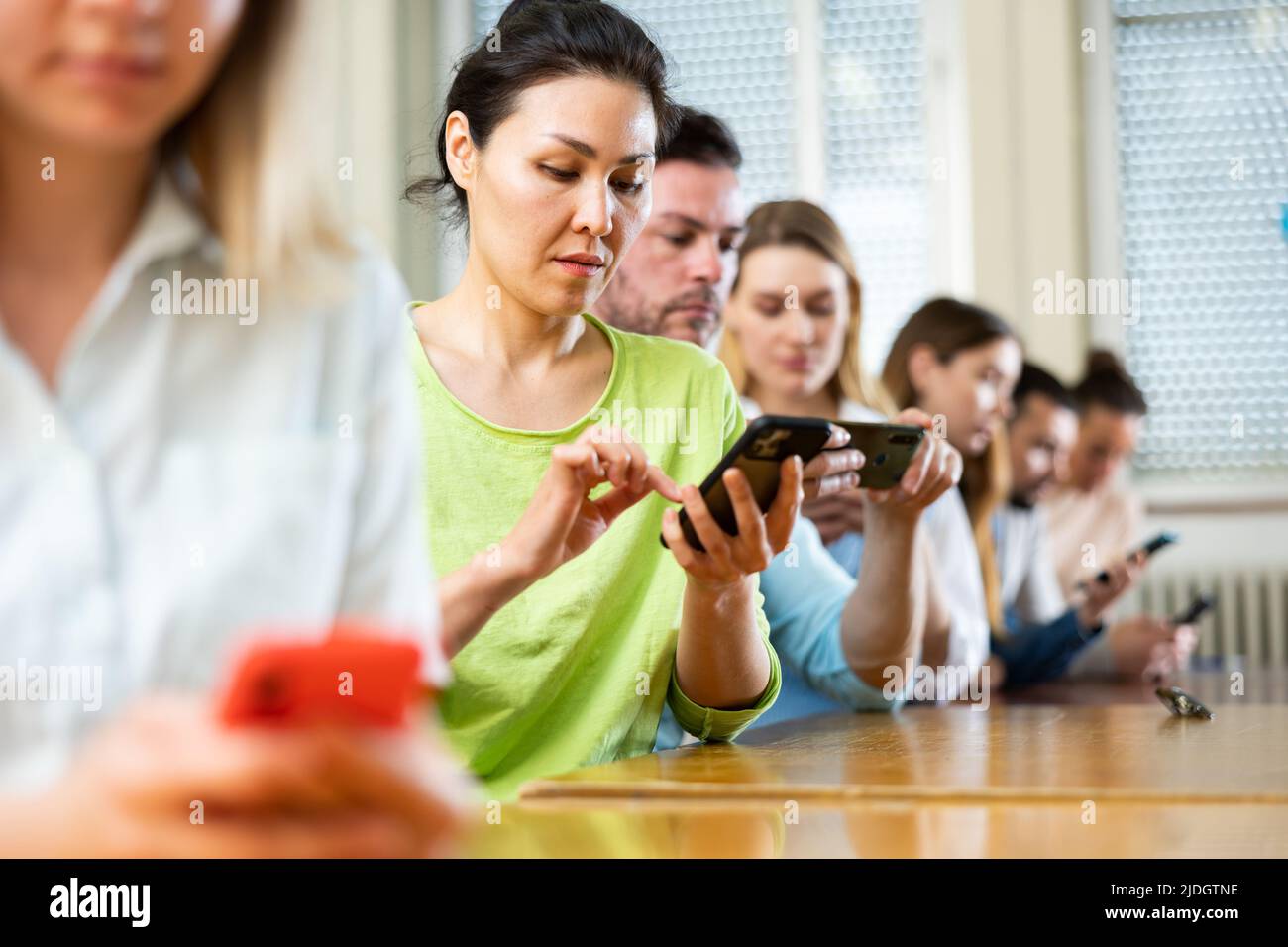 Portrait of students using mobile phones during lesson Stock Photo - Alamy