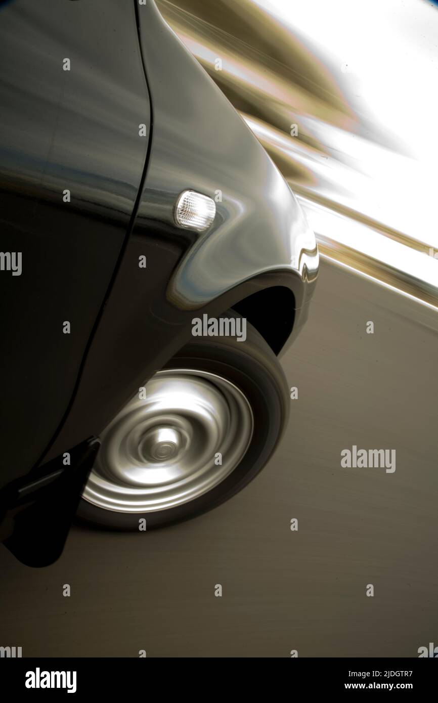 Black car turning sharply to its right, showing speed in tracking blur ...