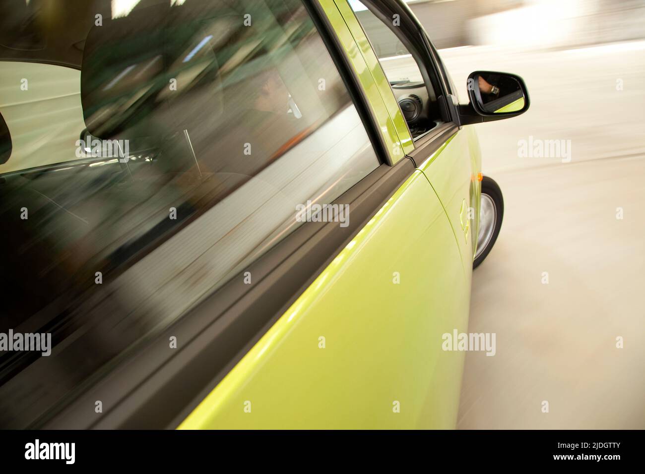 Detail of a car going around a corner in a built environment, creating ...