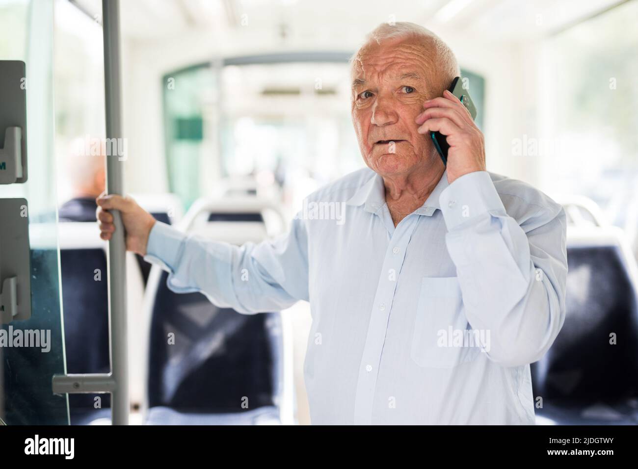 Old man talking on phone in streetcar Stock Photo - Alamy