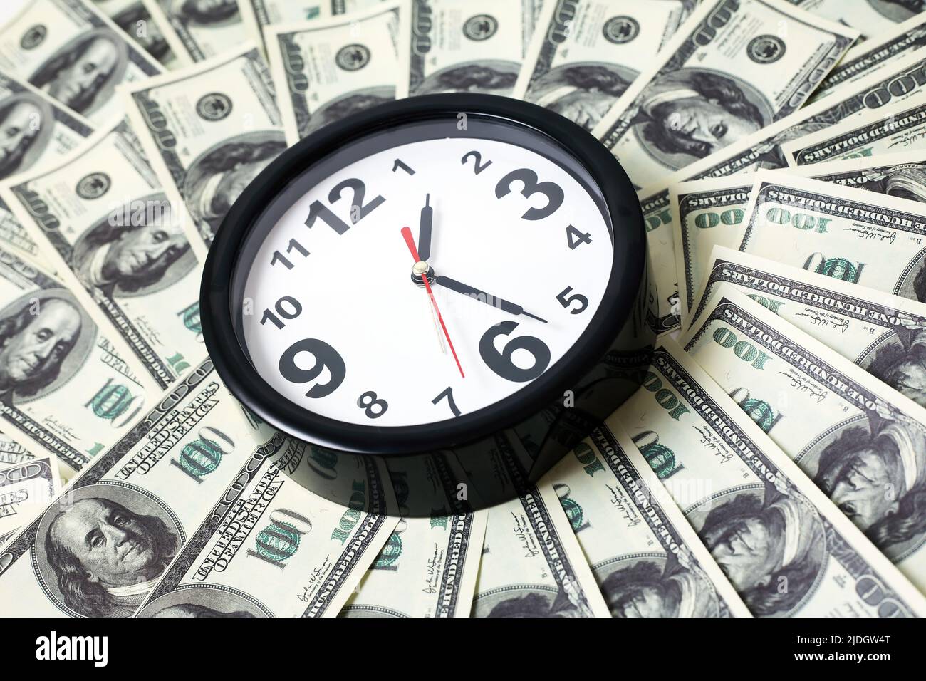 Time is money. Modern alarm clock on USA cash background Stock Photo ...