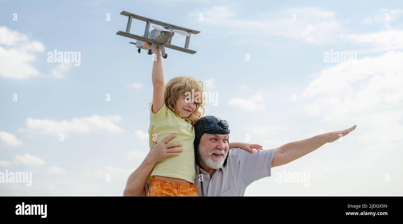 Grandfather and son having fun with toy plane on sky. Child dreams of ...