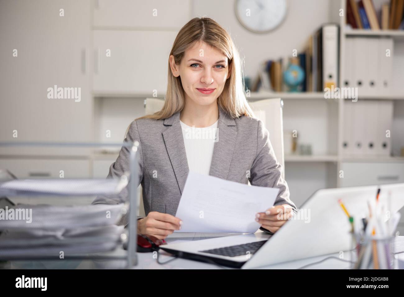 Woman working in office with documents and laptop Stock Photo - Alamy