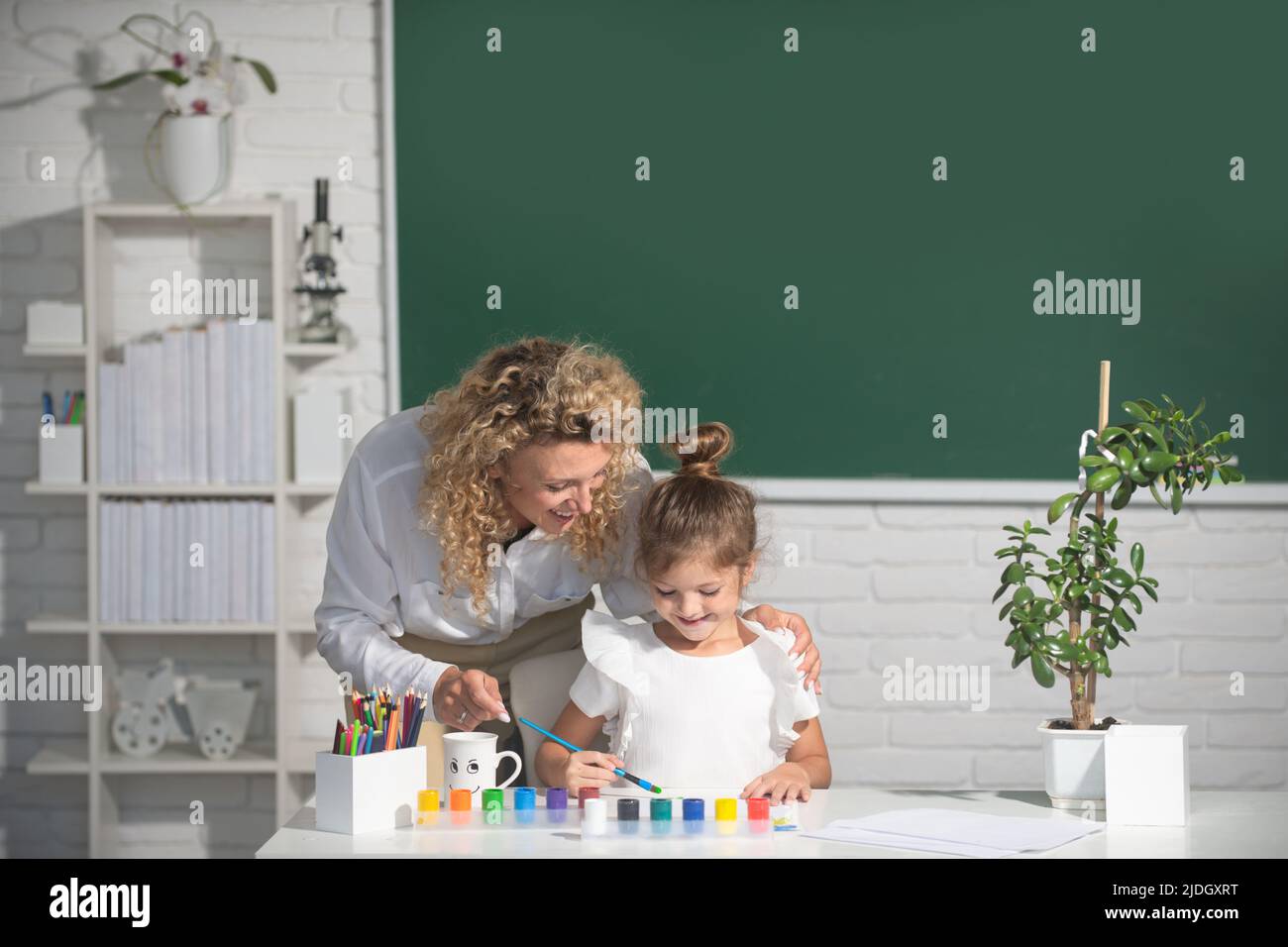 Back to school. Kid drawing with teacher. Children from elementary ...