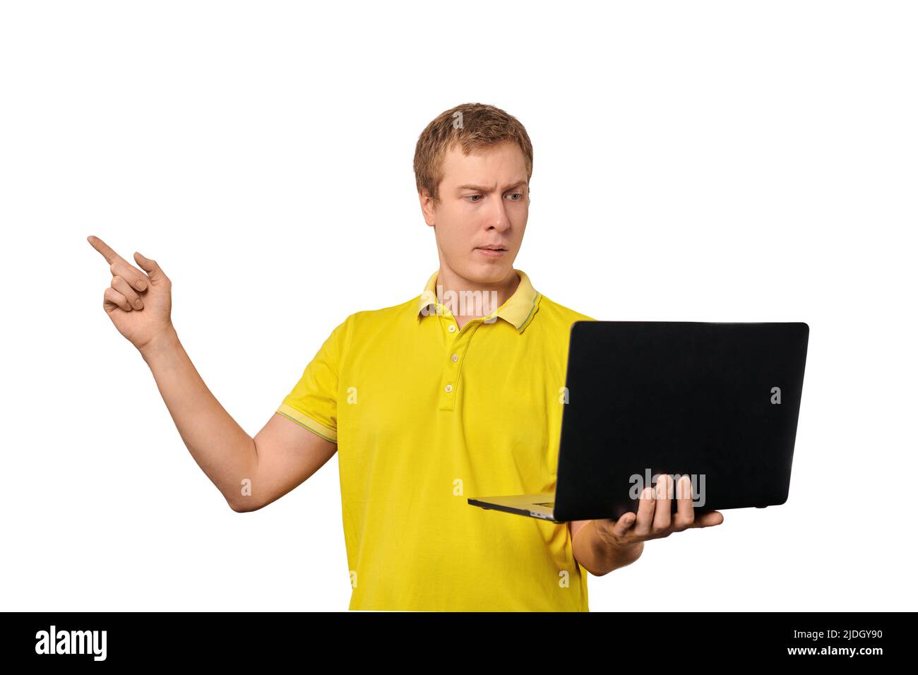 Puzzled young man in yellow T-short holding laptop in black case and ...